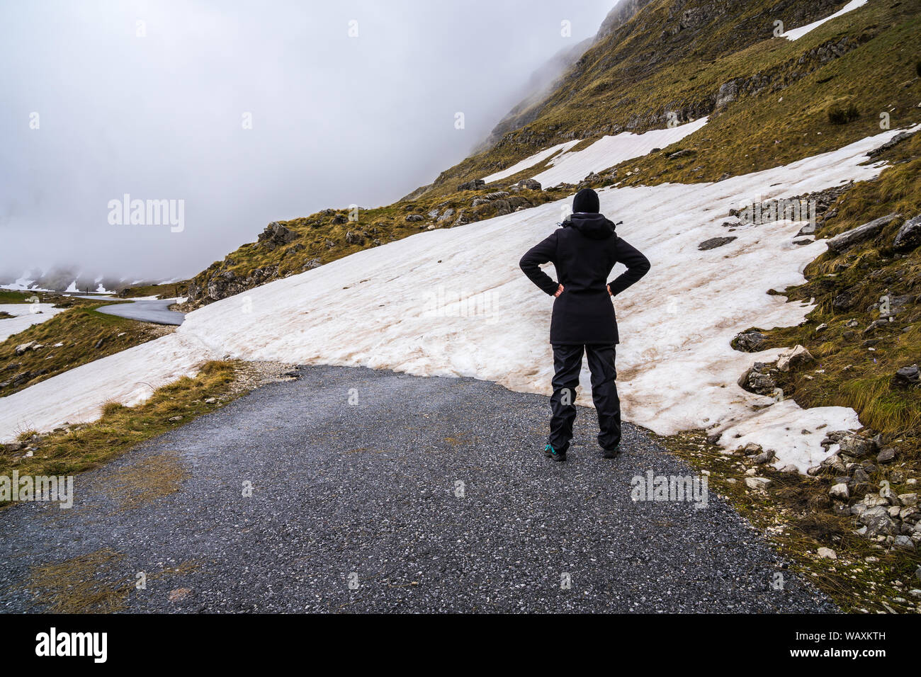 Montenegro, Woman standing on closed asphalt road of sedlo pass route ...