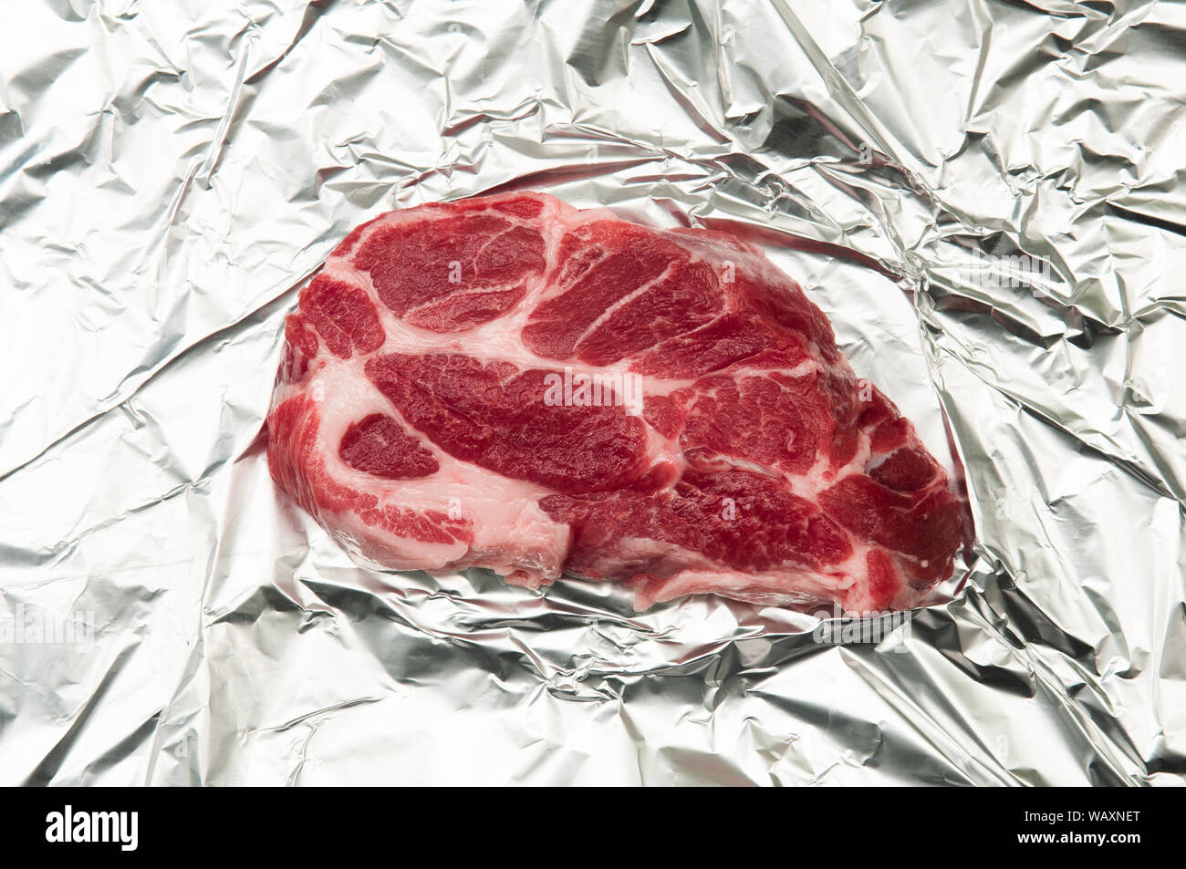 Raw red meat beef or pork with fat line on foil top view shot - Food ...