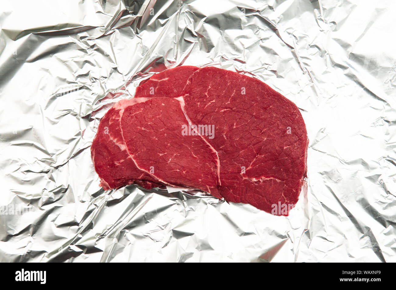 Raw red meat beef or pork with fat line on foil top view shot - Food ...