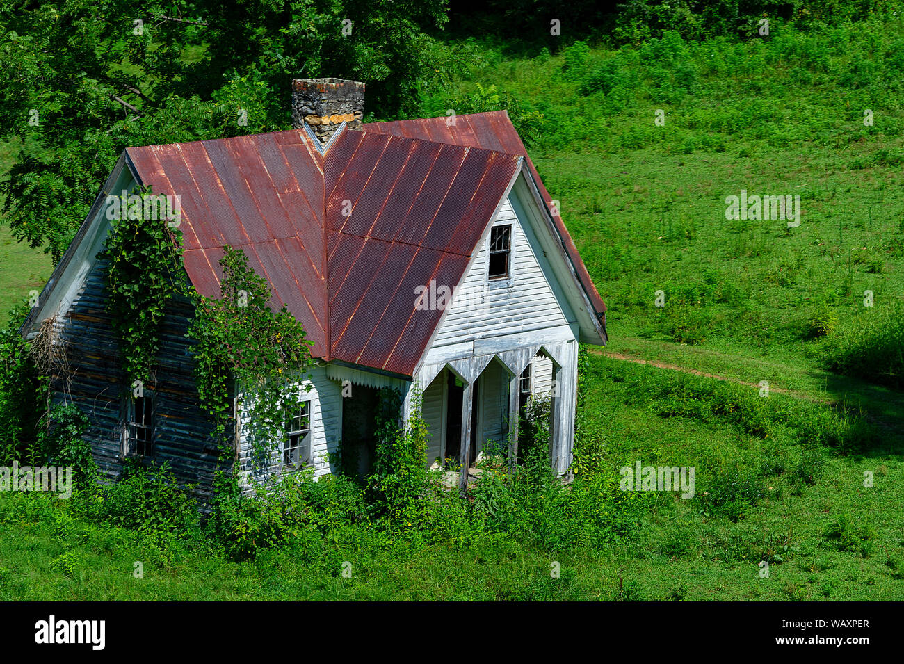 An old abandoned home with vines overtaking it is seen from above ...