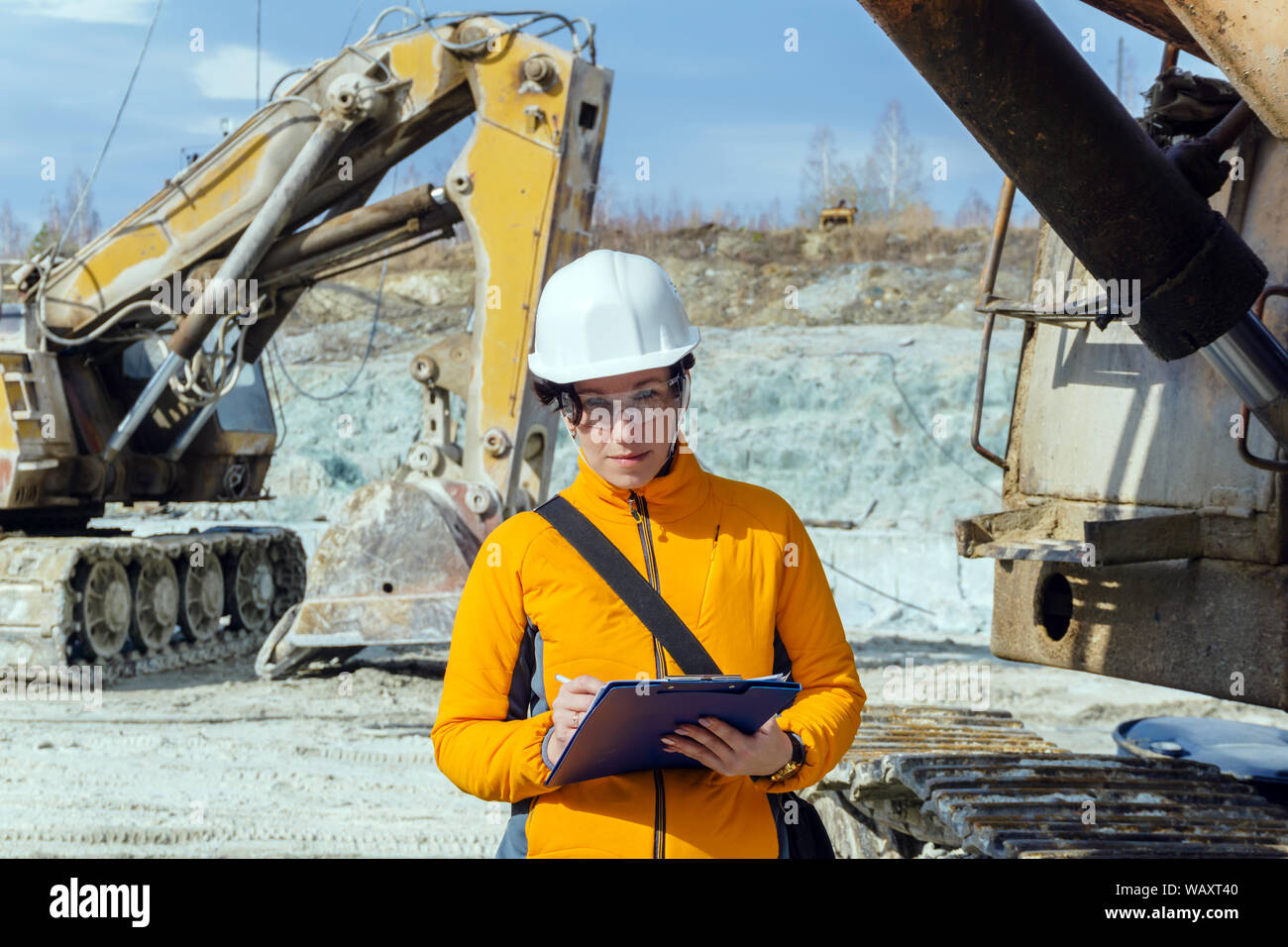 female geologist or a mining engineer writes something in a map-case ...