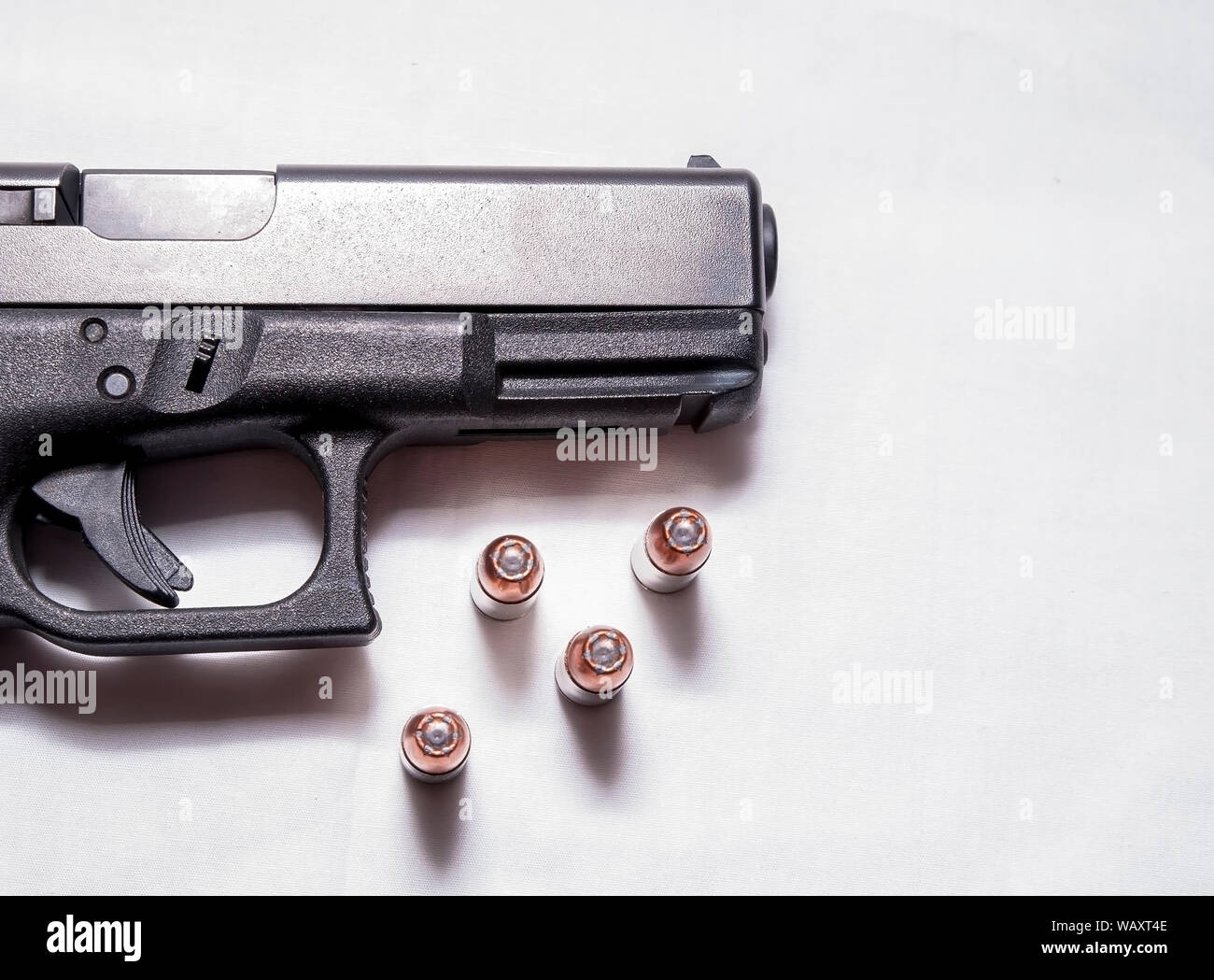 A black 9mm pistol with four hollow point bullets in front of it on a ...