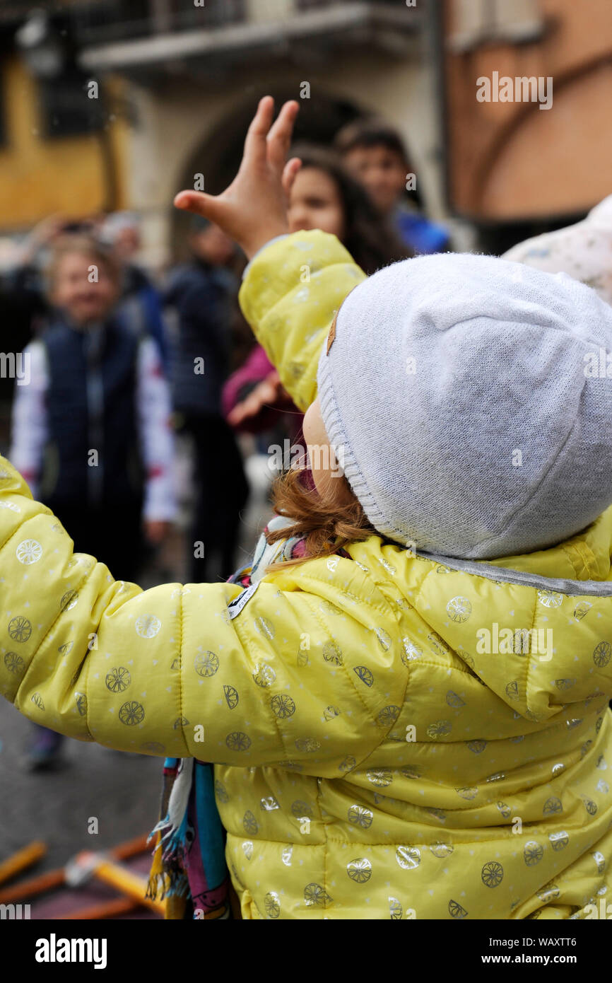 Back view of little girl on winter day in the street. Happy children ...