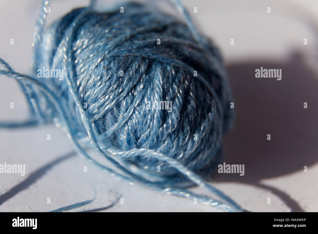 a light blue yarn seam with cotton thread on light simple background at ...