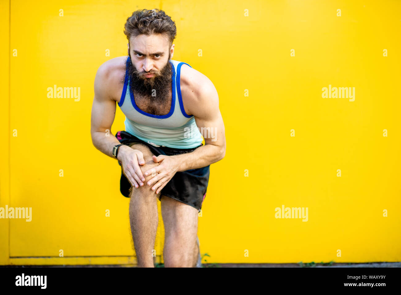 Portrait of an old-fashioned runner dressed in 80s style standing on ...