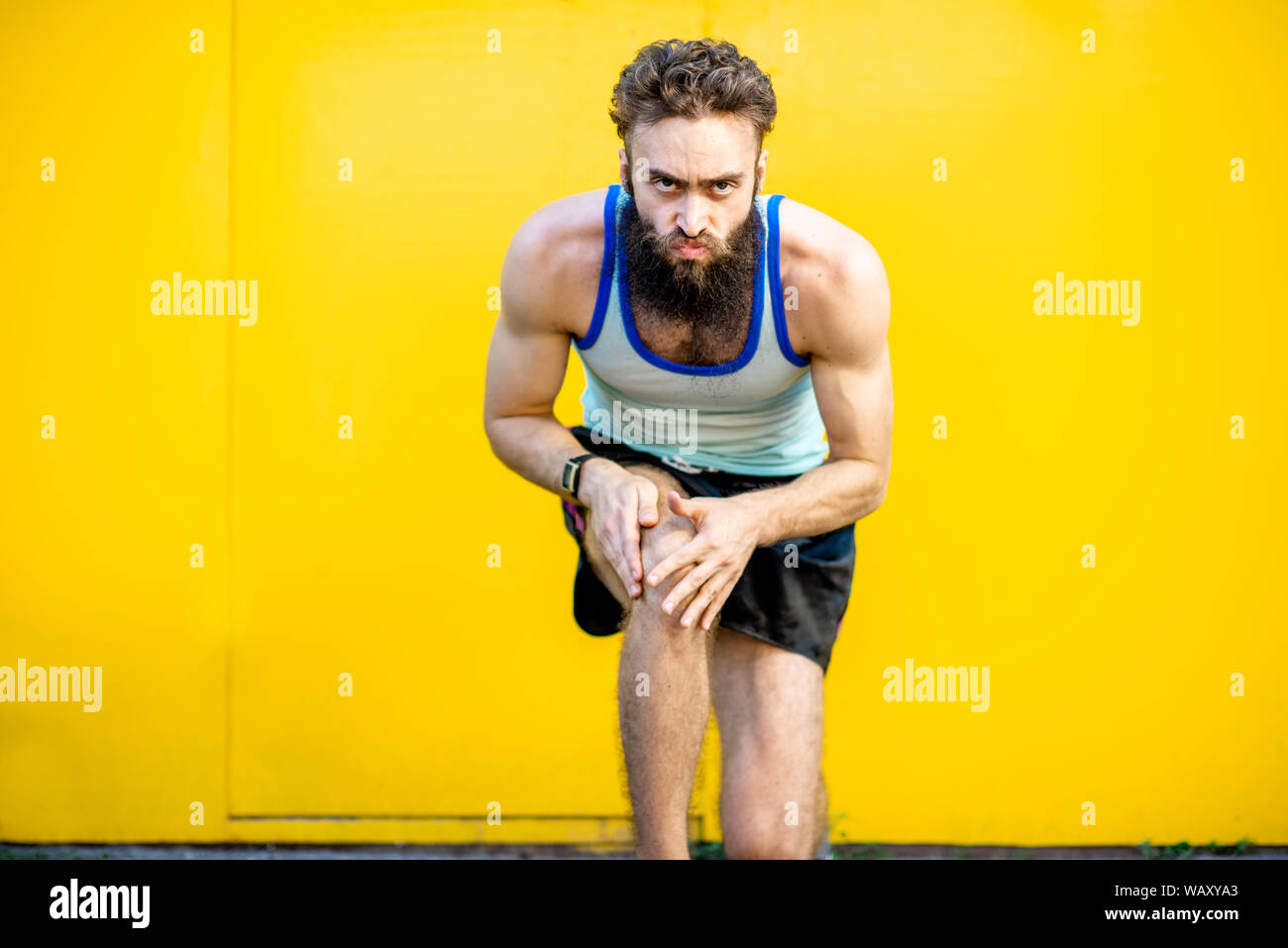 Portrait of an old-fashioned runner dressed in 80s style standing on ...