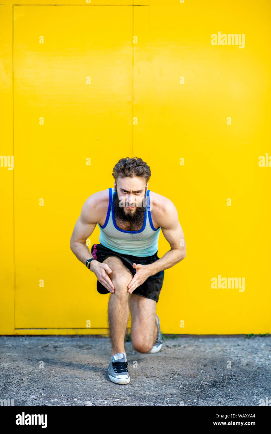 Portrait of an old-fashioned runner dressed in 80s style standing on ...