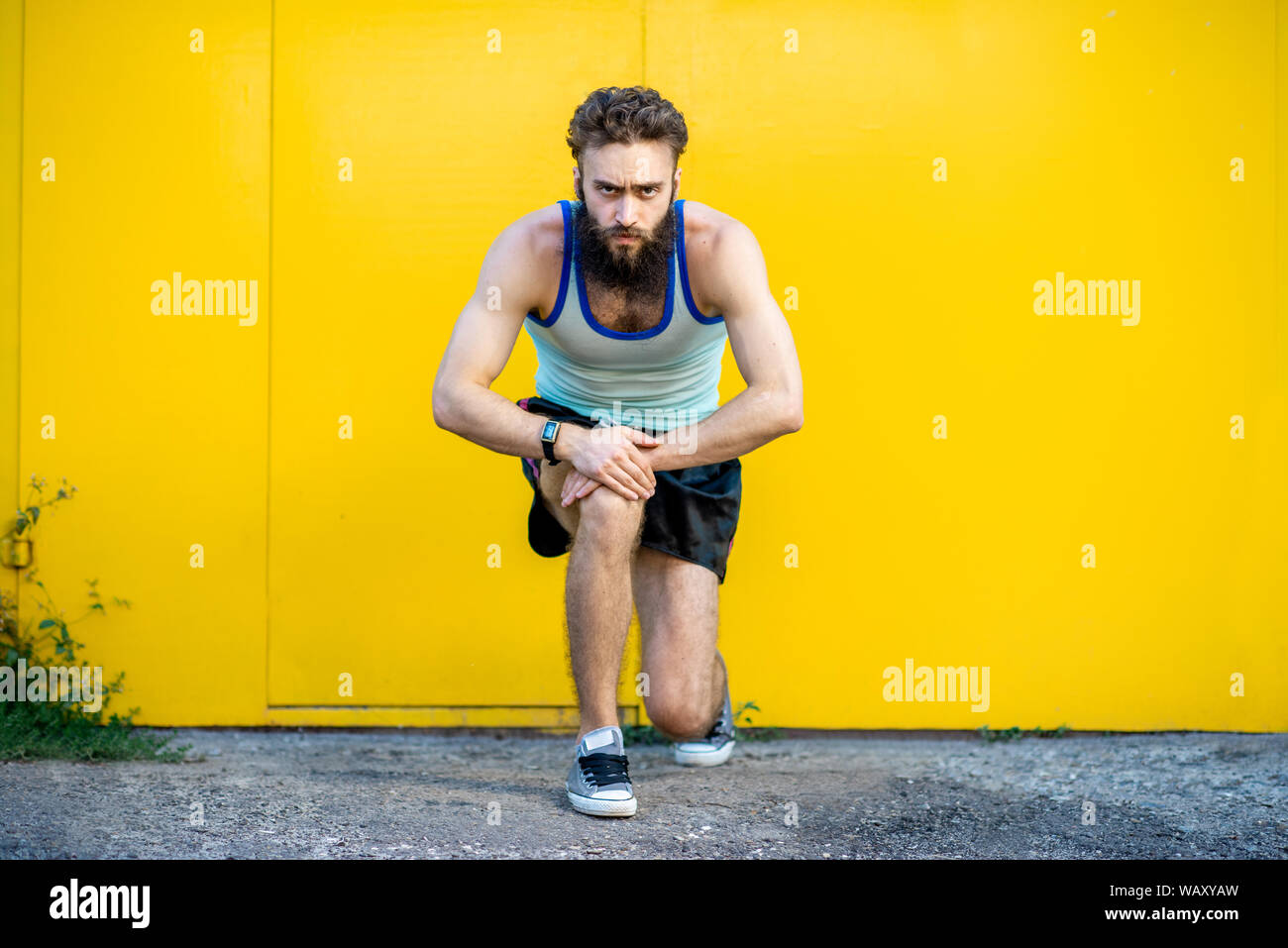 Portrait of an old-fashioned runner dressed in 80s style standing on ...