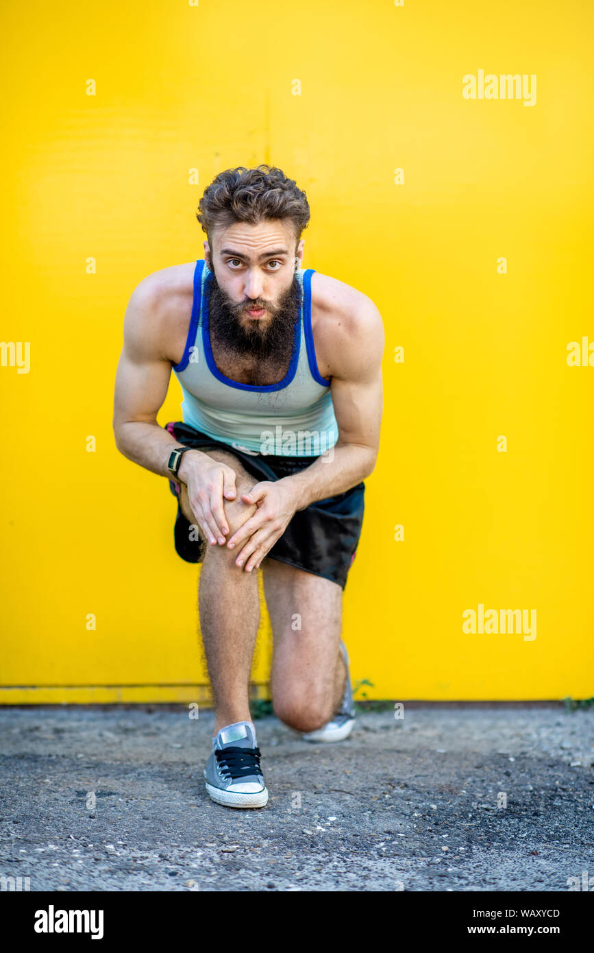 Portrait of an old-fashioned runner dressed in 80s style standing on ...