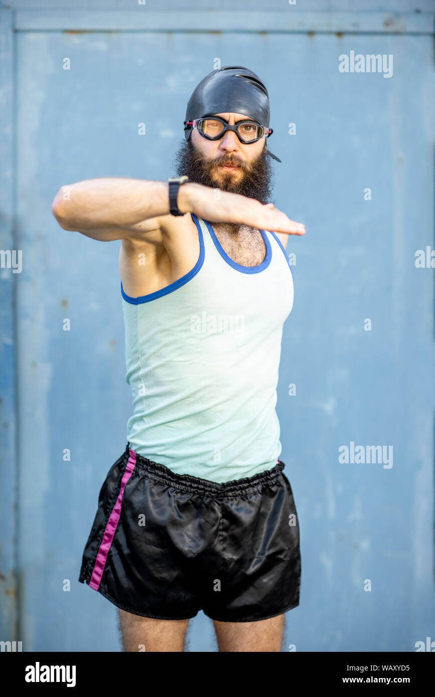 Portrait of a weird, old-fashioned swimmer dressed in 80s style with ...