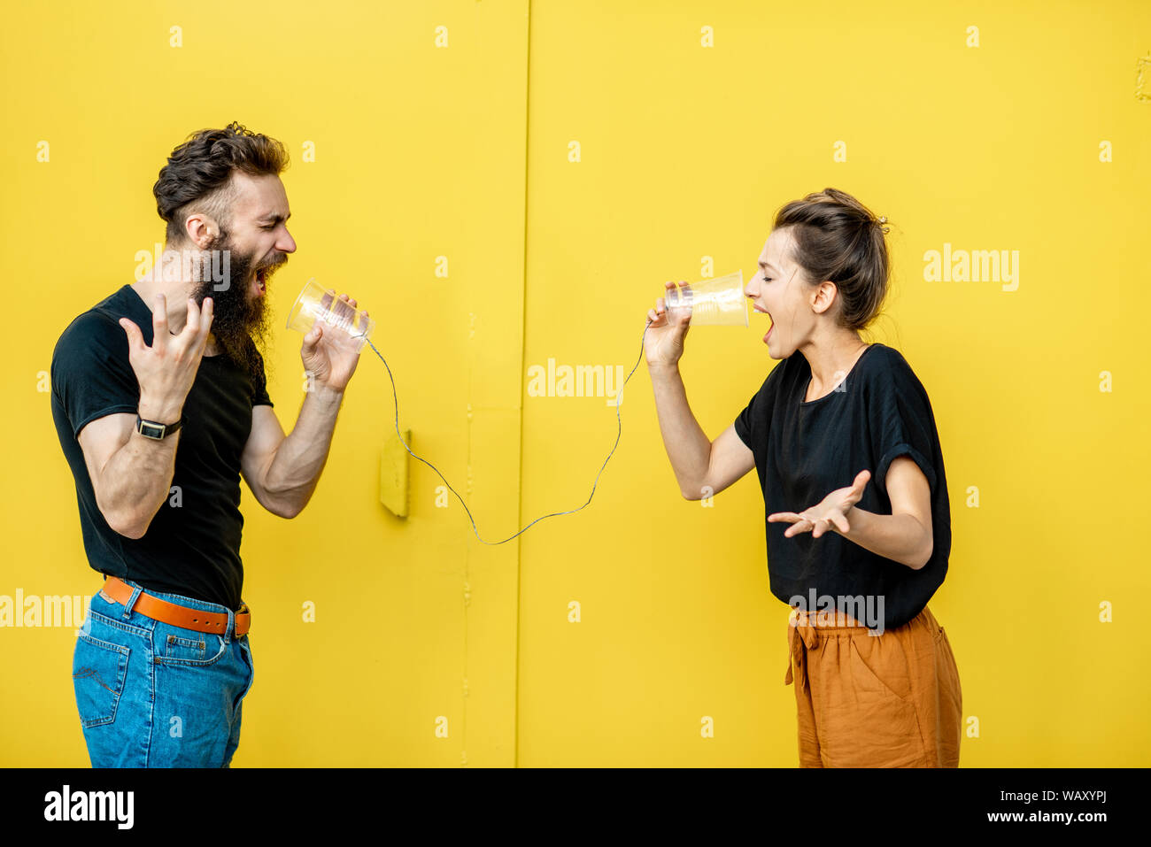 Man and woman talking with string phone, shouting on each other on the ...