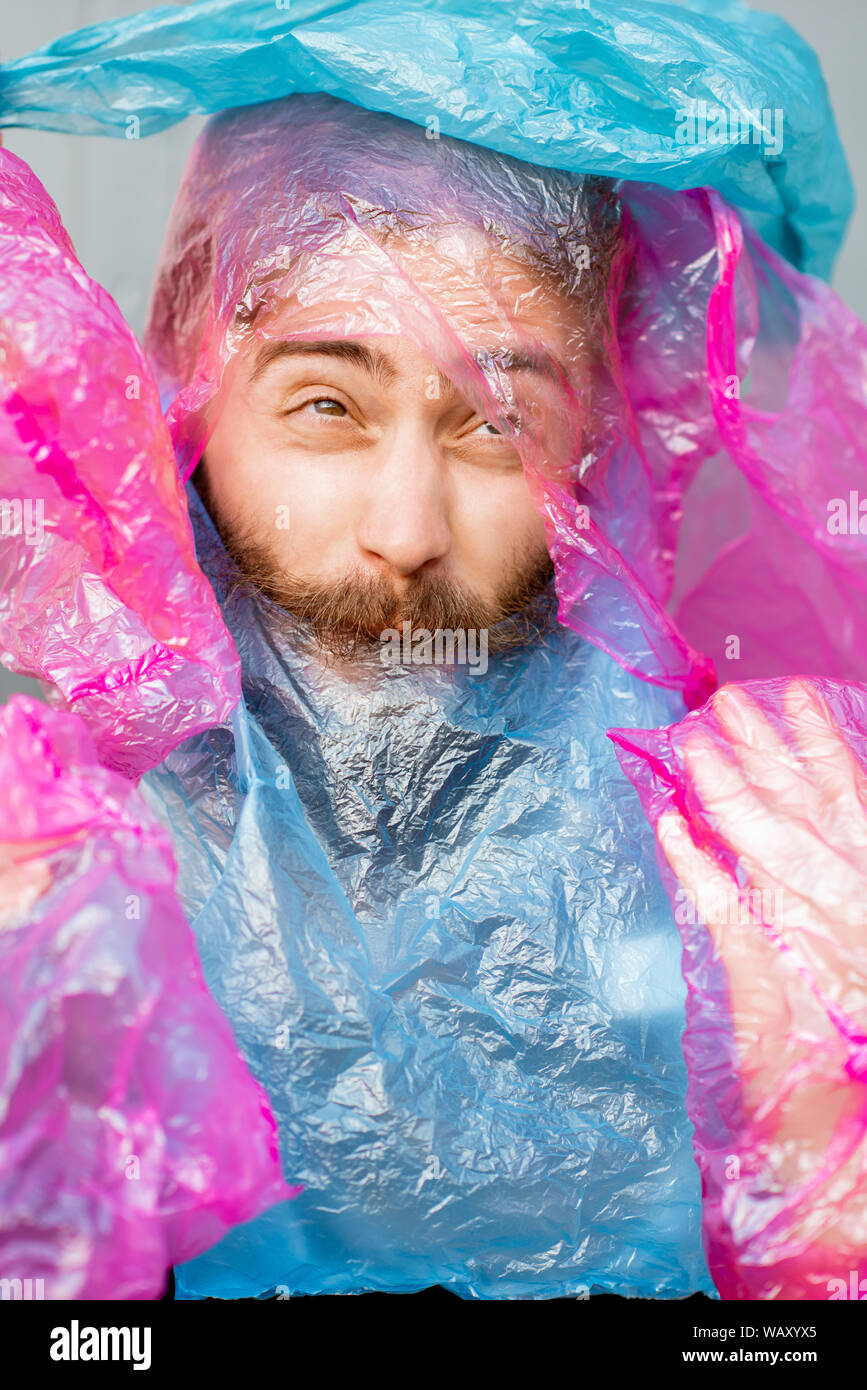 Close-up portrait of hopelessness man wrapped with disposable plastic ...