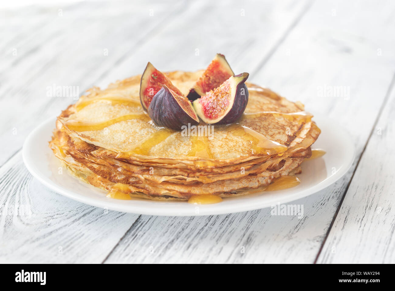 Stack of homemade crepes with fresh fig and sweet topping on the white ...