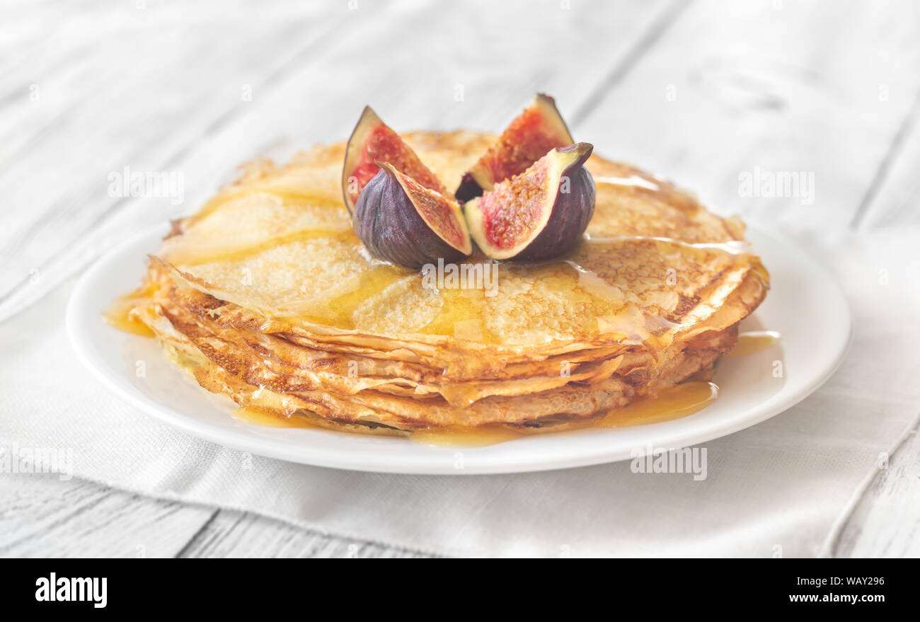 Stack of homemade crepes with fresh fig and sweet topping on the white ...