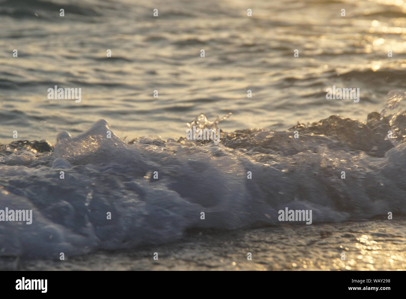 setting sun reflecting off the ocean wave Stock Photo - Alamy