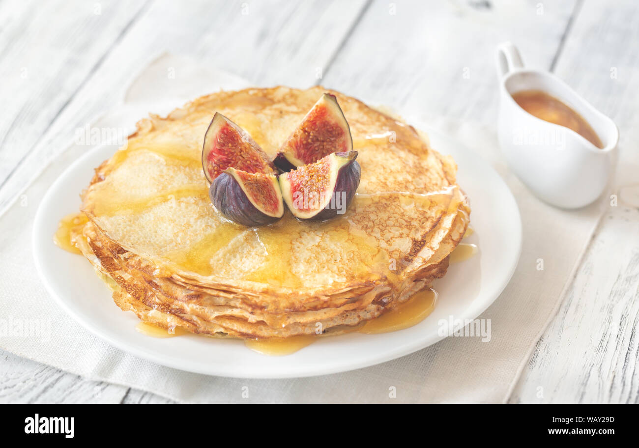 Stack of homemade crepes with fresh fig and sweet topping on the white ...