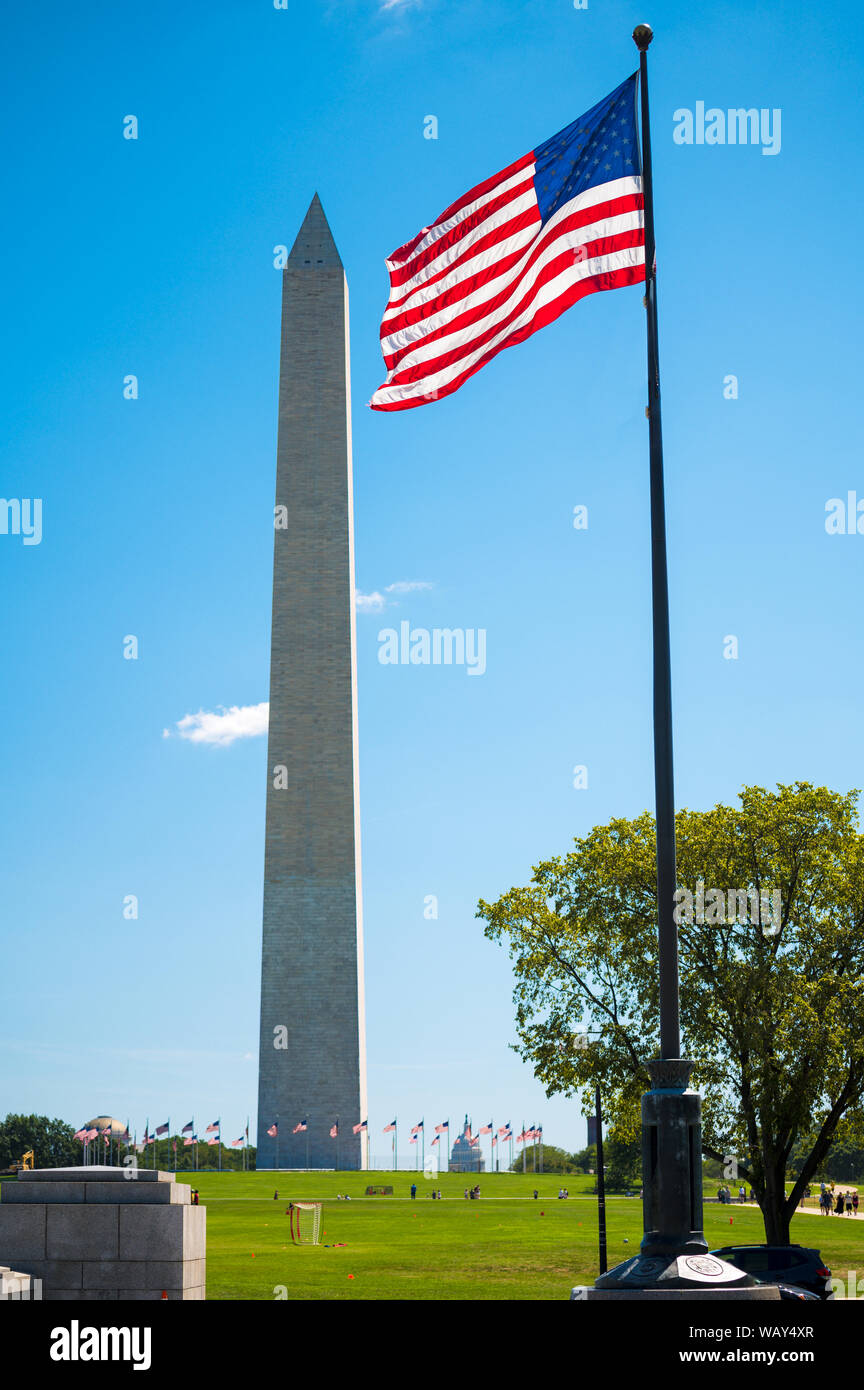 US flag flying from a pole with Washington Monument in background Stock ...