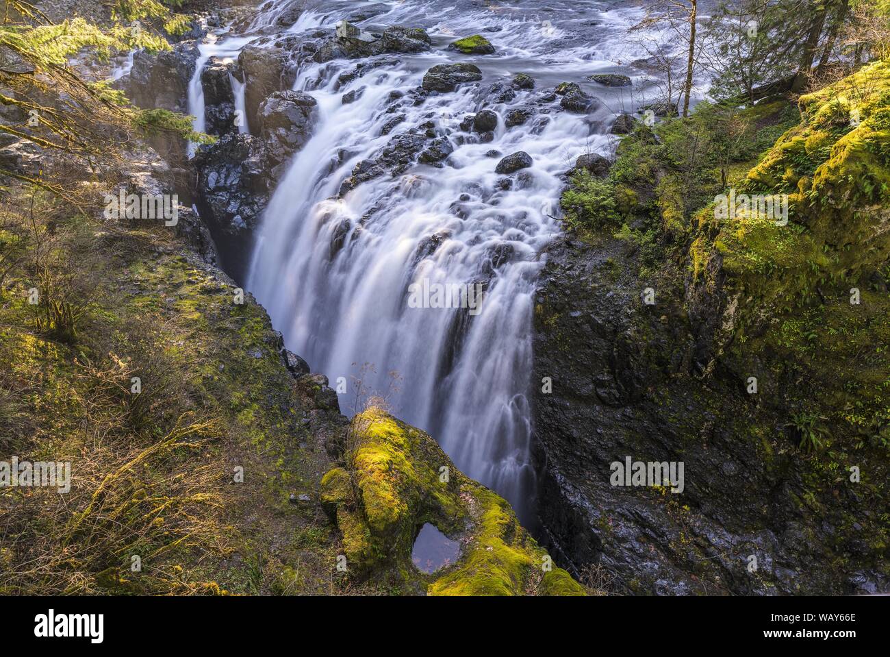 Beautiful landscape shot of waterfalls flowing down a green cliff Stock ...