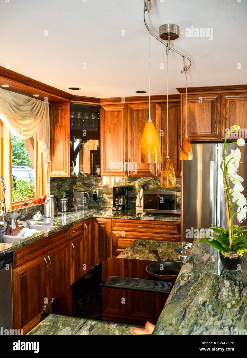 Stylish kitchen wooden interior with ceramic stove on island table ...
