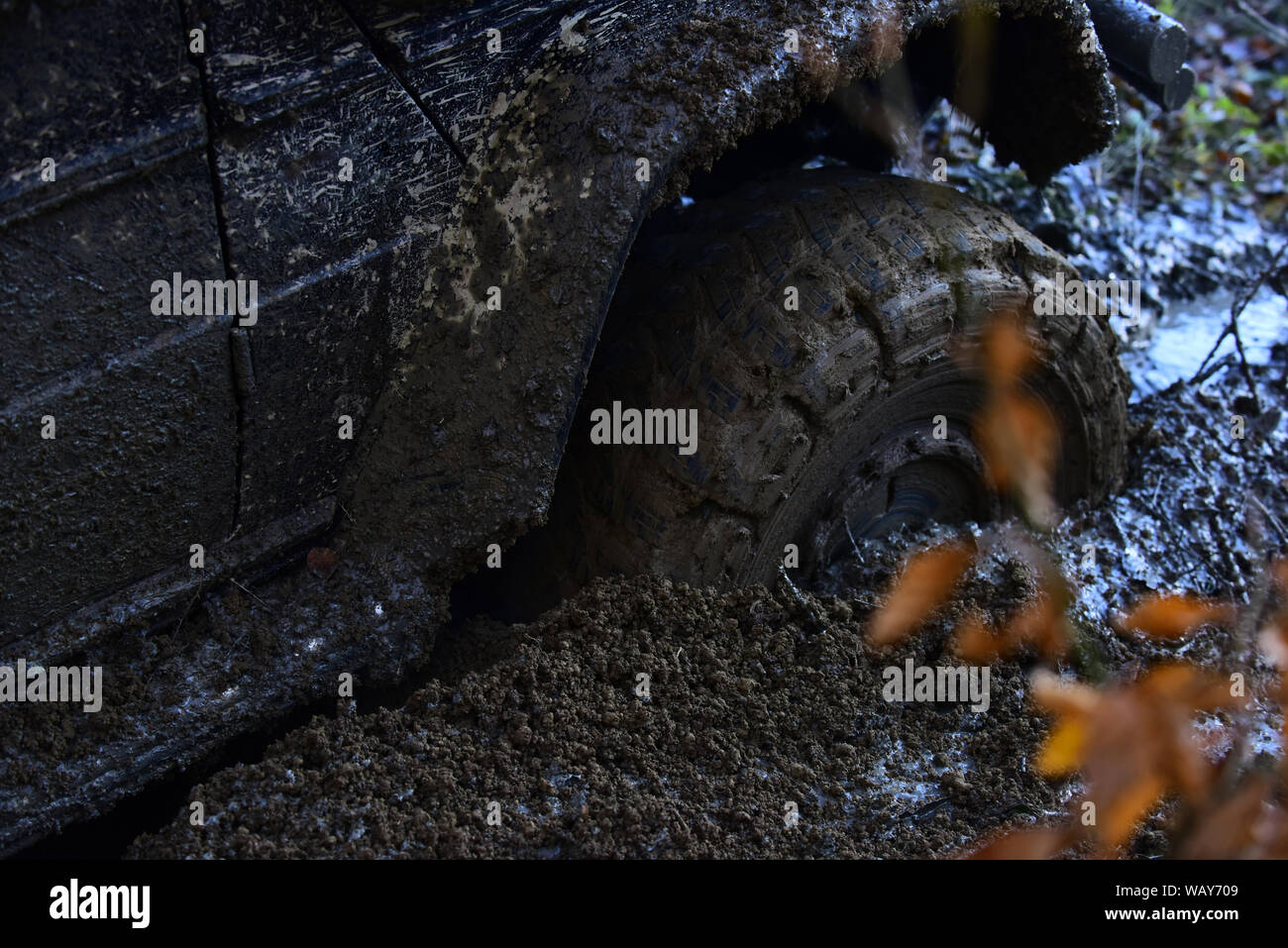 Offroad tire covered with mud overcomes obstacles on nature background ...