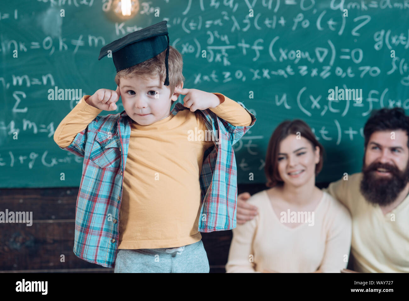 Wunderkind concept. Smart child, wunderkind in graduate cap pointing at ...