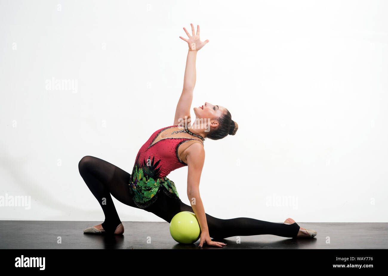 Beautiful brunette girl dancing with ball isolated on white background ...