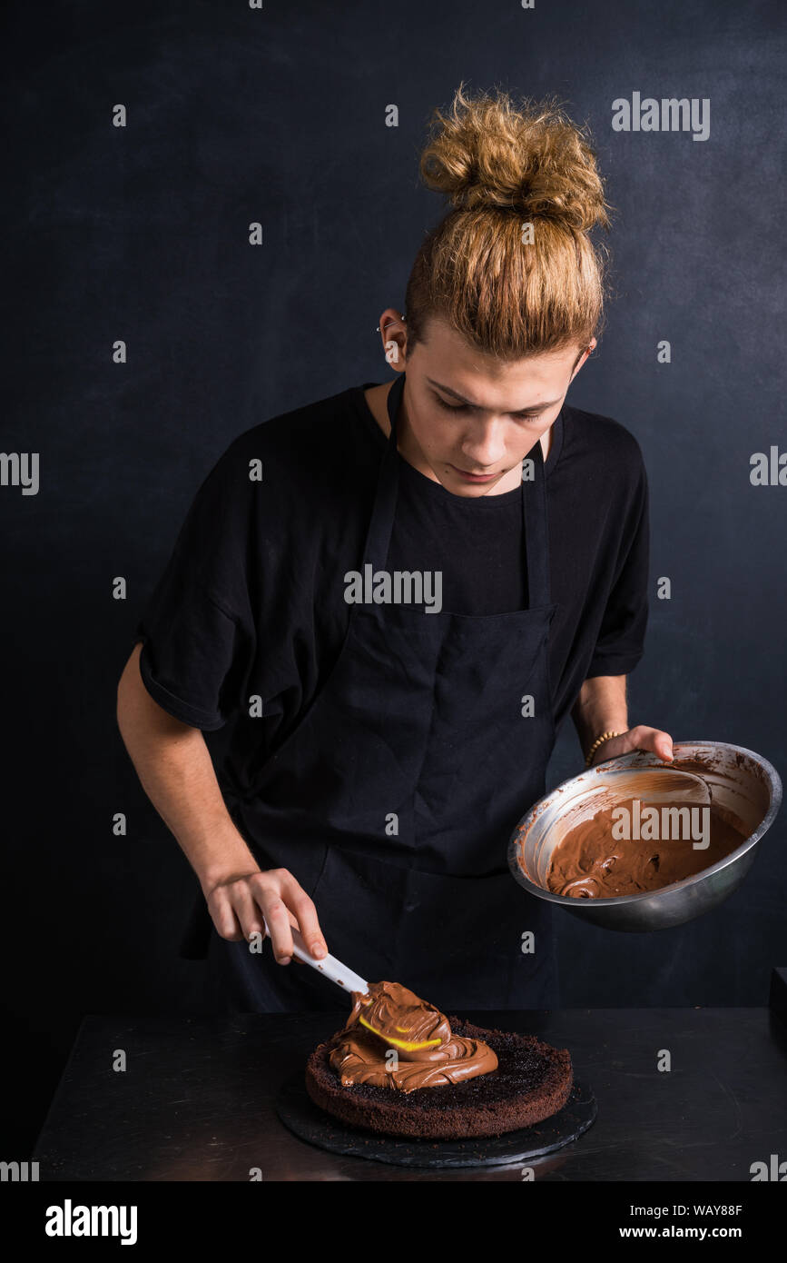 Men in black decorating chocolate cake this a cream Stock Photo - Alamy