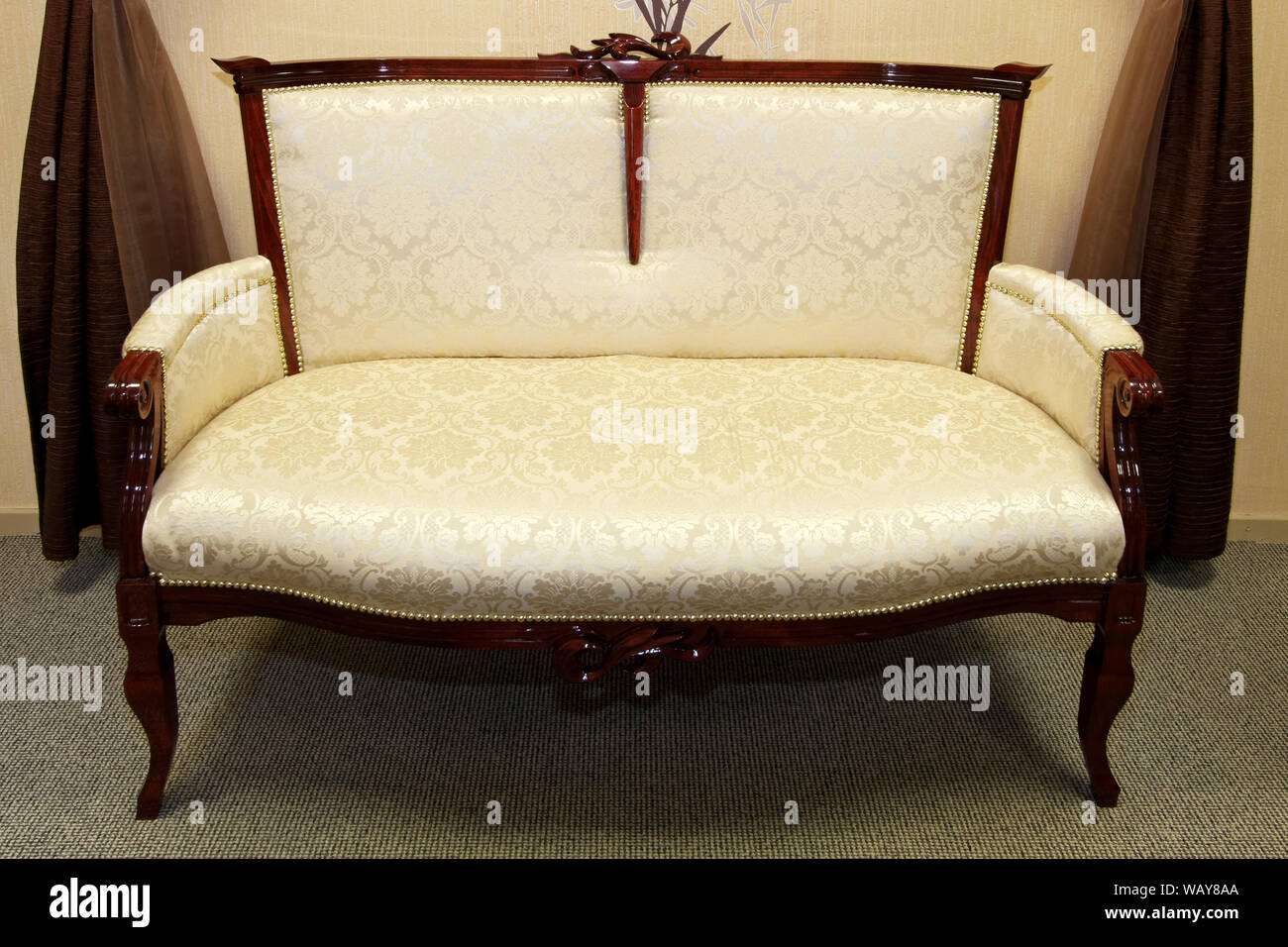 Beige sofa in classic style with wooden details Stock Photo - Alamy