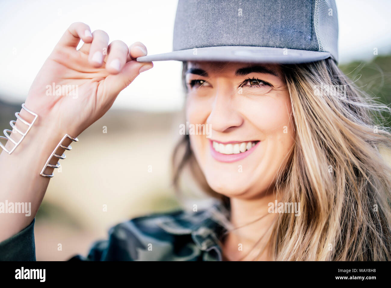 Pretty blonde woman with cap posing at camera Stock Photo - Alamy