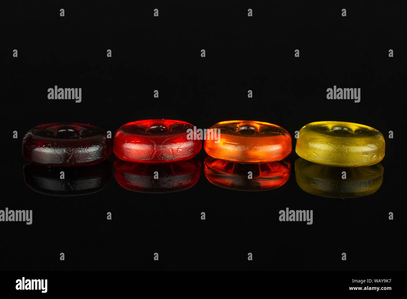 Group of four whole colourful hard candy dark red cherry orange yellow ...