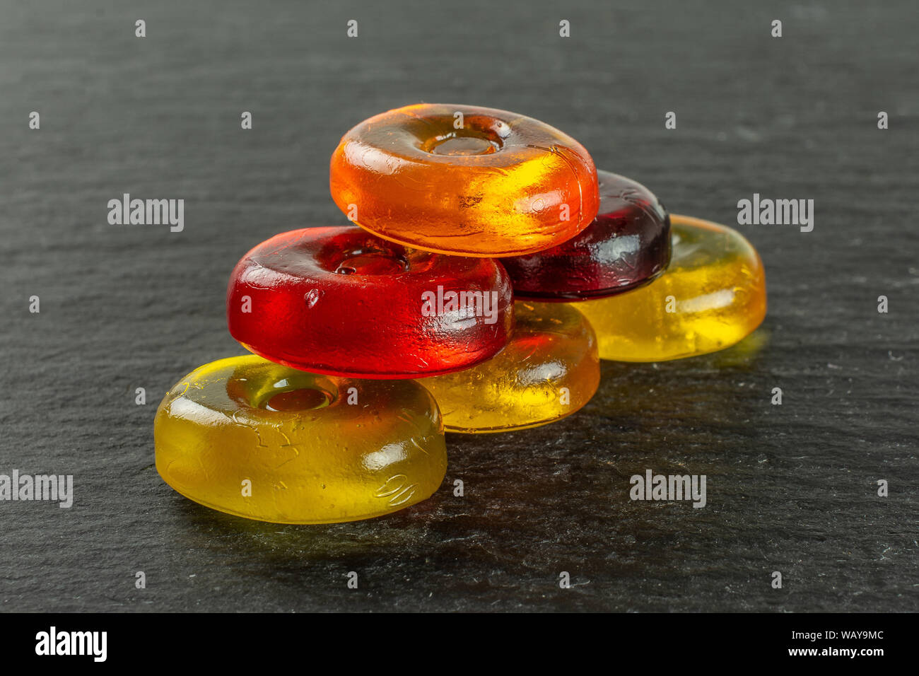 Group of six whole colourful hard candy pyramid on grey stone Stock ...