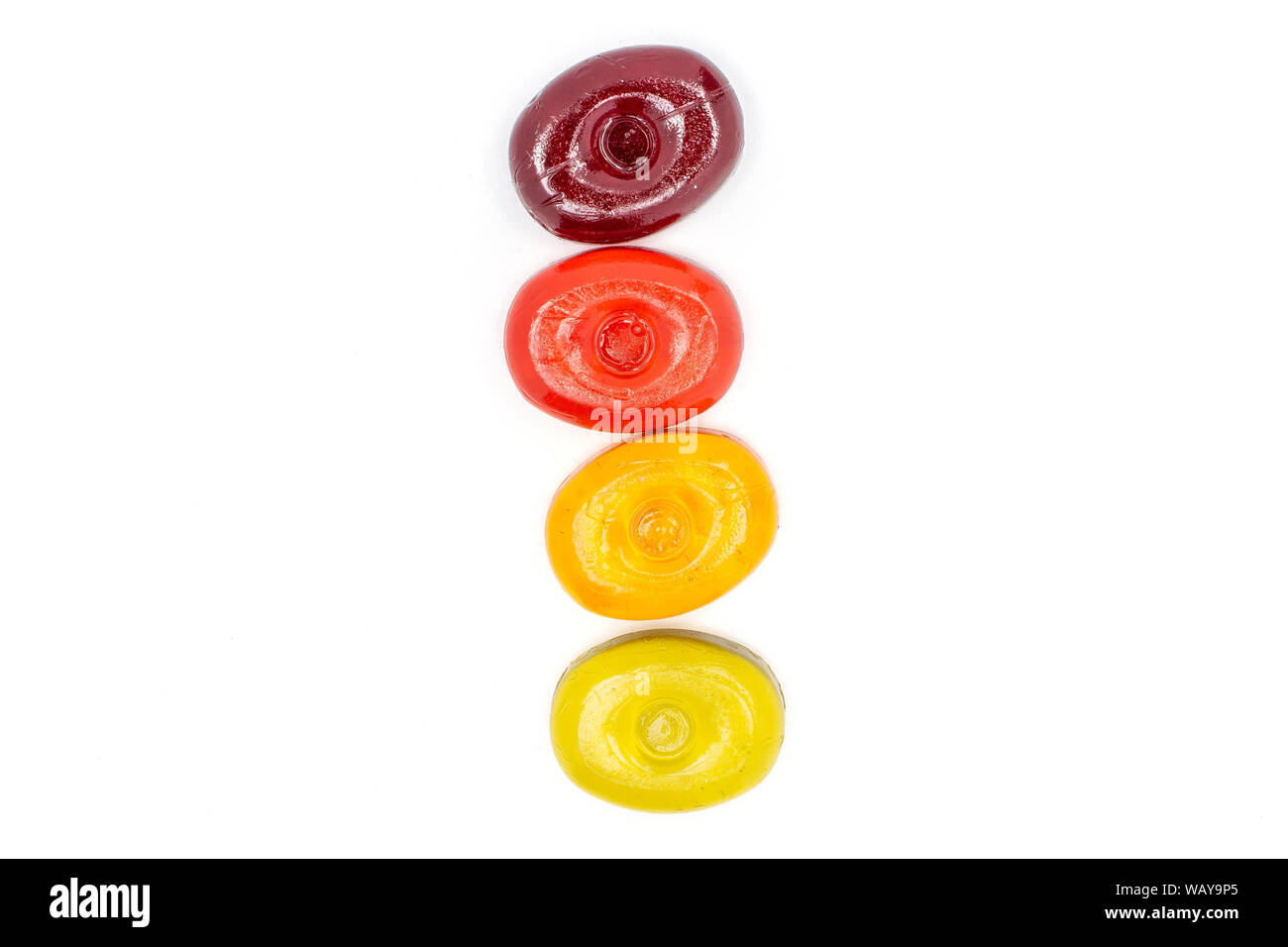 Group of four whole colourful hard candy in line flatlay isolated on ...