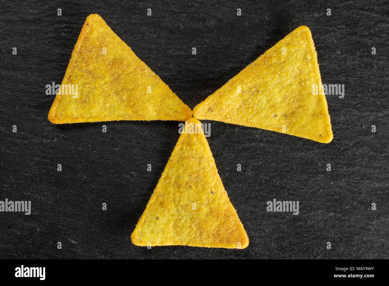 Group of three whole cheese tortilla chips like hazard symbol flatlay ...