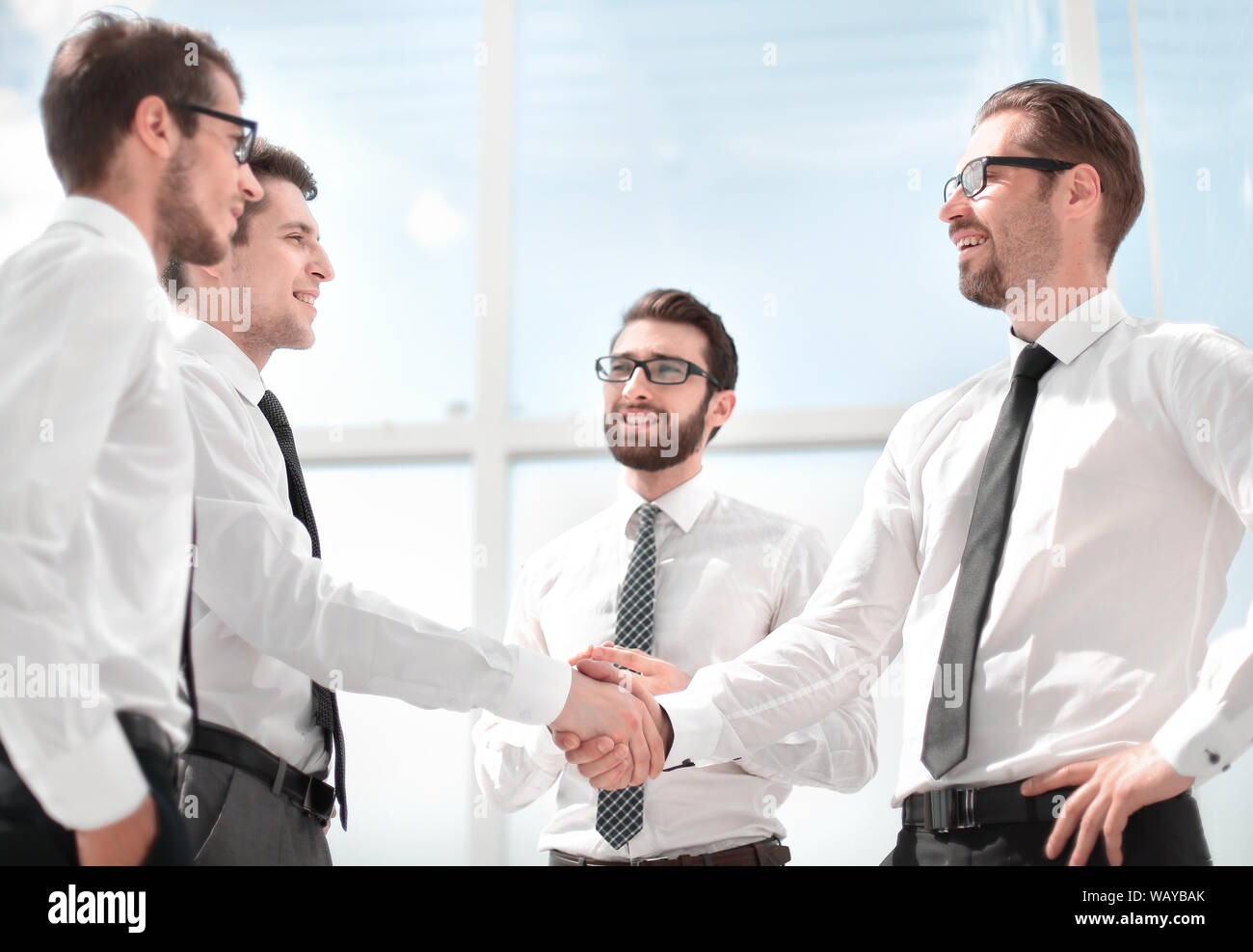 handshake of young business partners standing in the office Stock Photo - Alamy