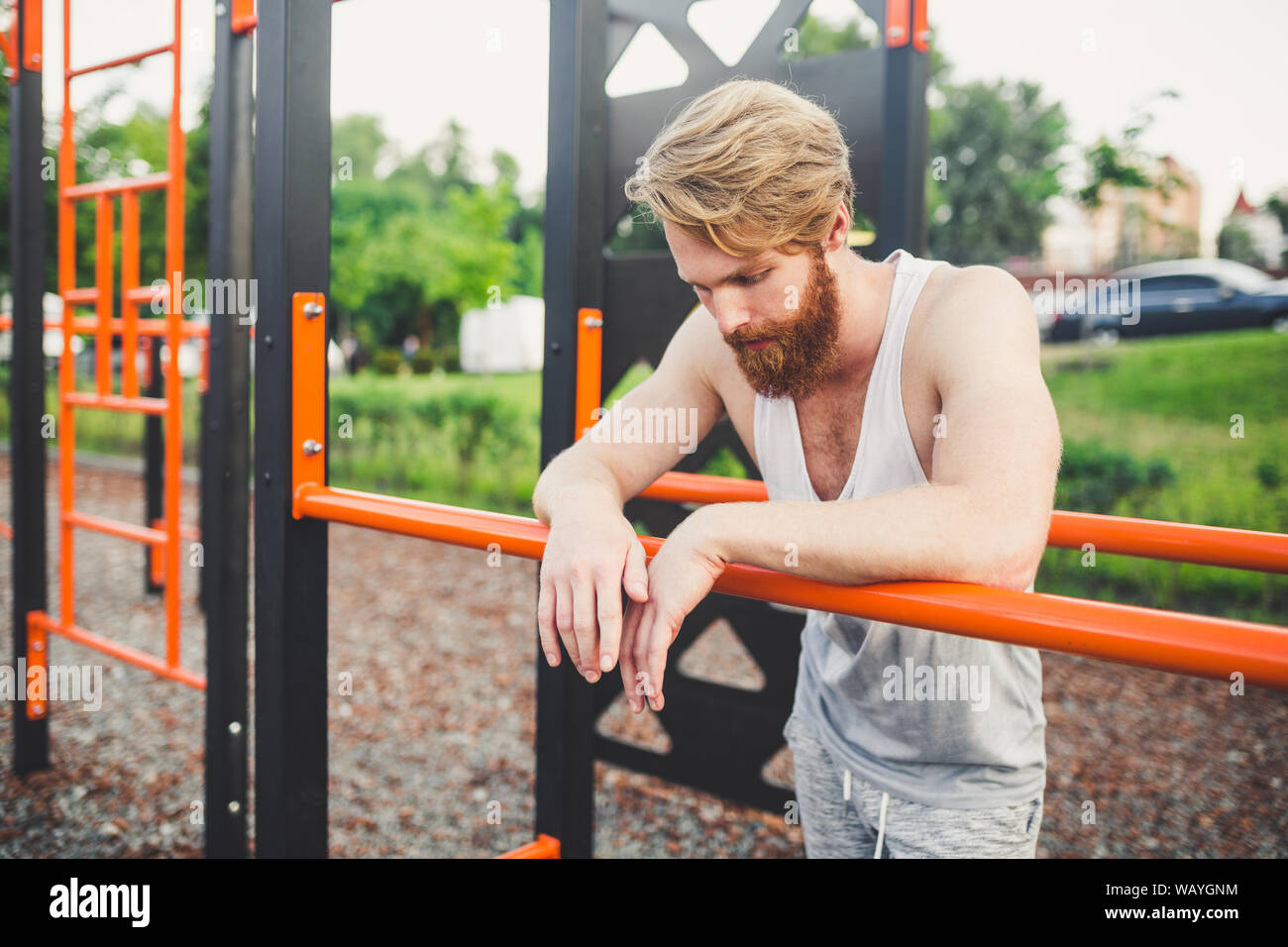 Portrait of Tired Athlete at Gym. Tired man hanging from the bar ...