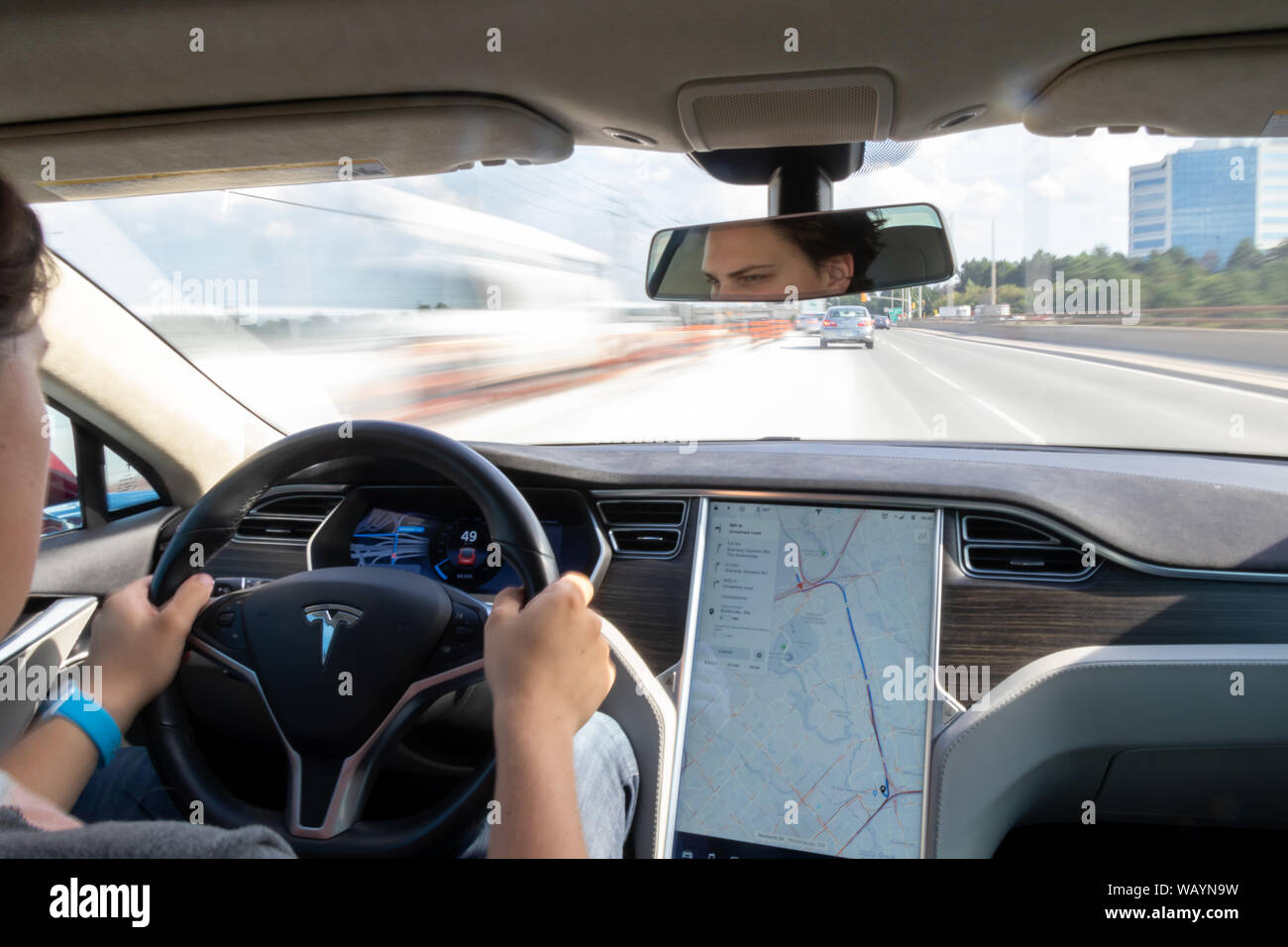 Man driving Tesla Model S while travelling on a busy road. (long ...