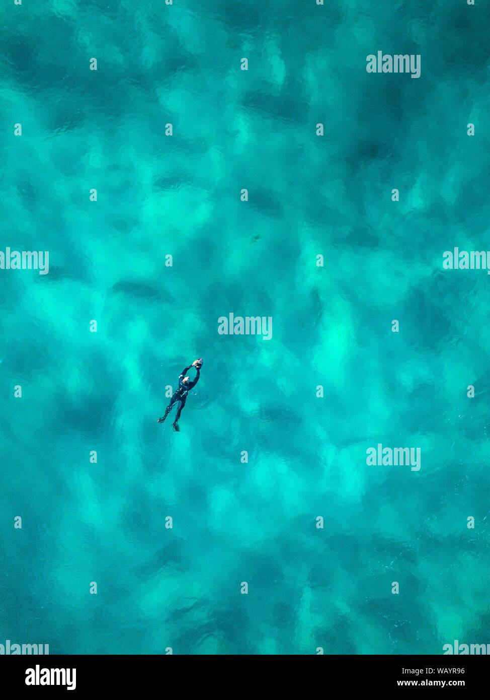 Overhead vertical shot of a swimmer swimming in a clear blue sea Stock ...