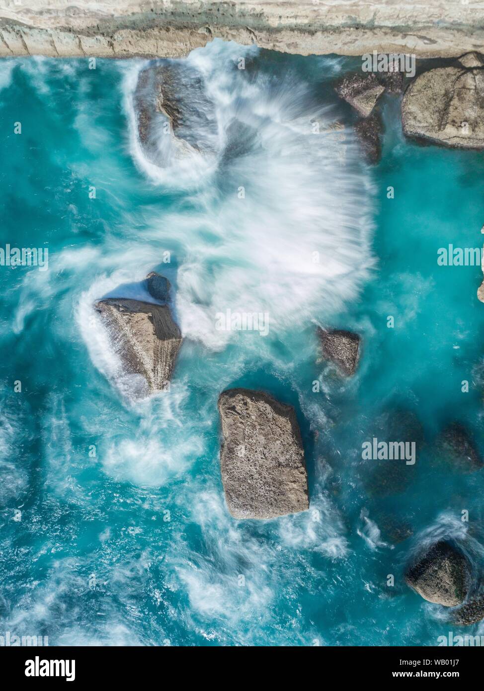 Vertical overhead shot of rock formations on the body of blue sea Stock ...