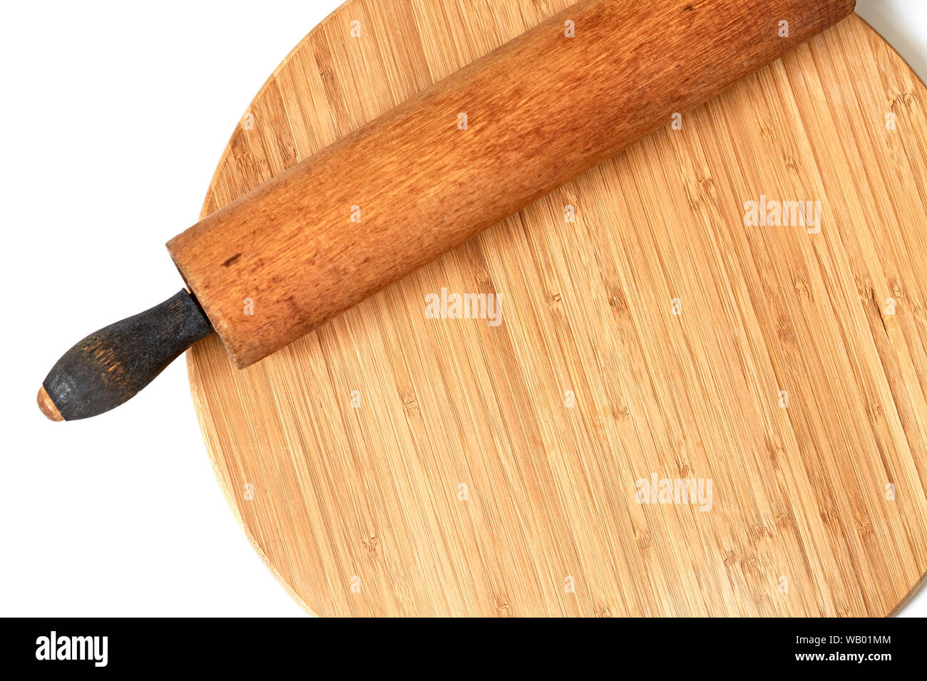 A wooden rolling pin on a bamboo cutting board isolated on white Stock ...