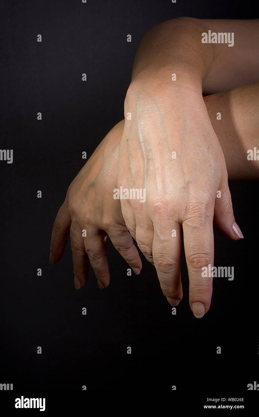 Tired woman hands folded on top of each other on black background Stock ...