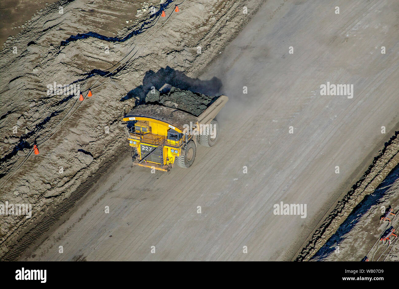 Giant trucks haul bitumen rich ore from mining operations to oil sands ...