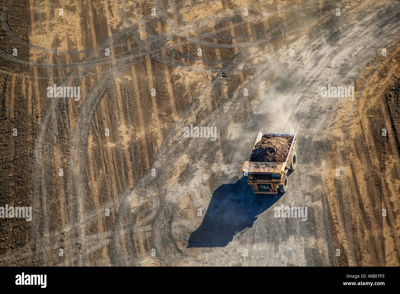 Giant trucks haul bitumen rich ore from mining operations to oil sands ...