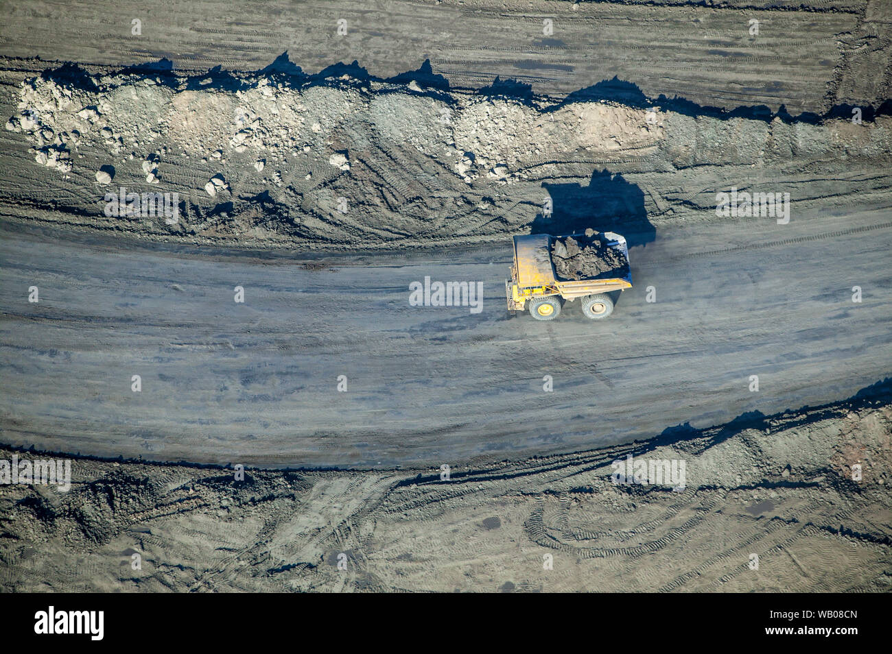 Giant trucks haul bitumen rich ore from mining operations to oil sands ...