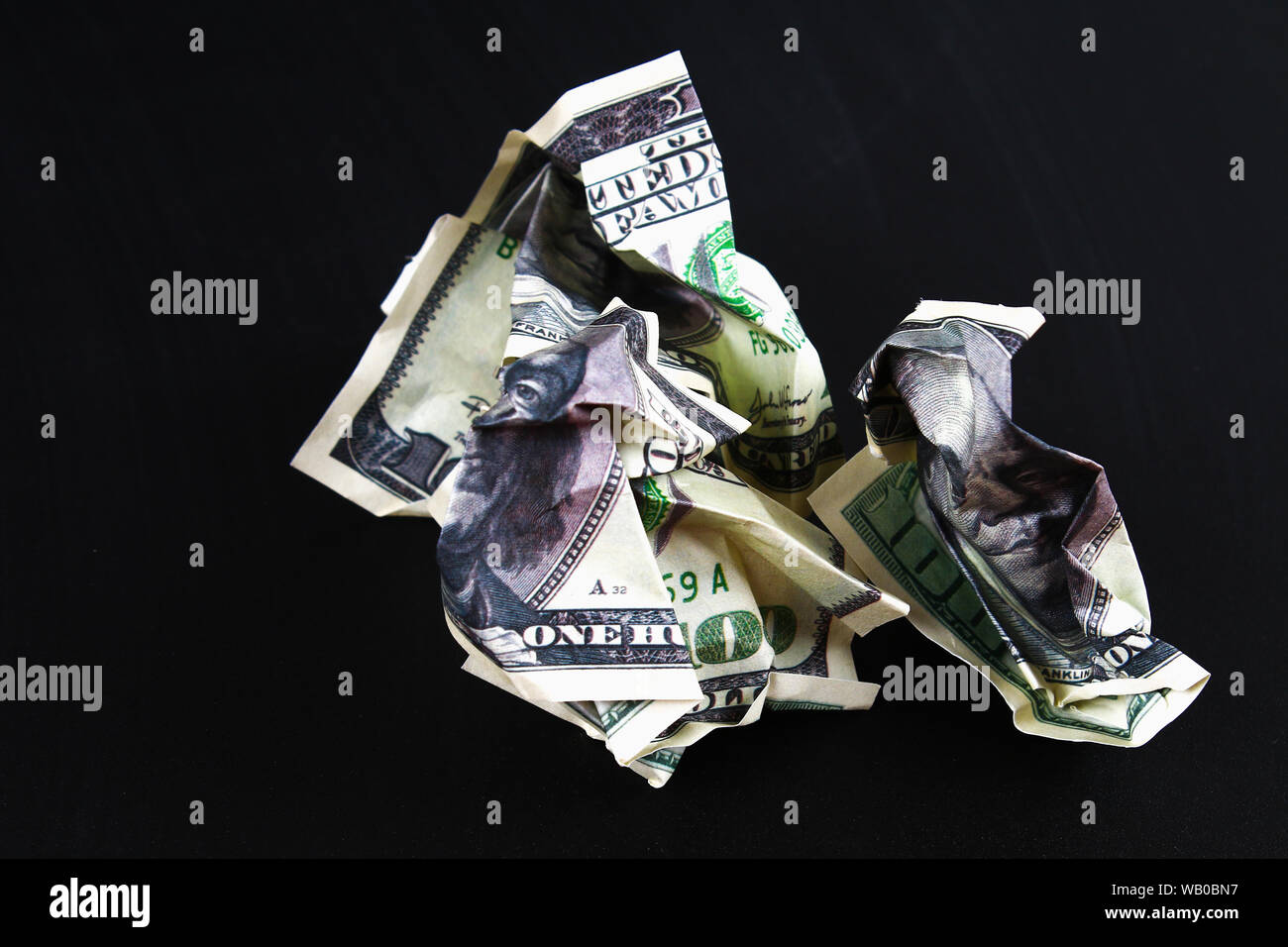 Crumpled one hundred American dollar on black paper background, close ...