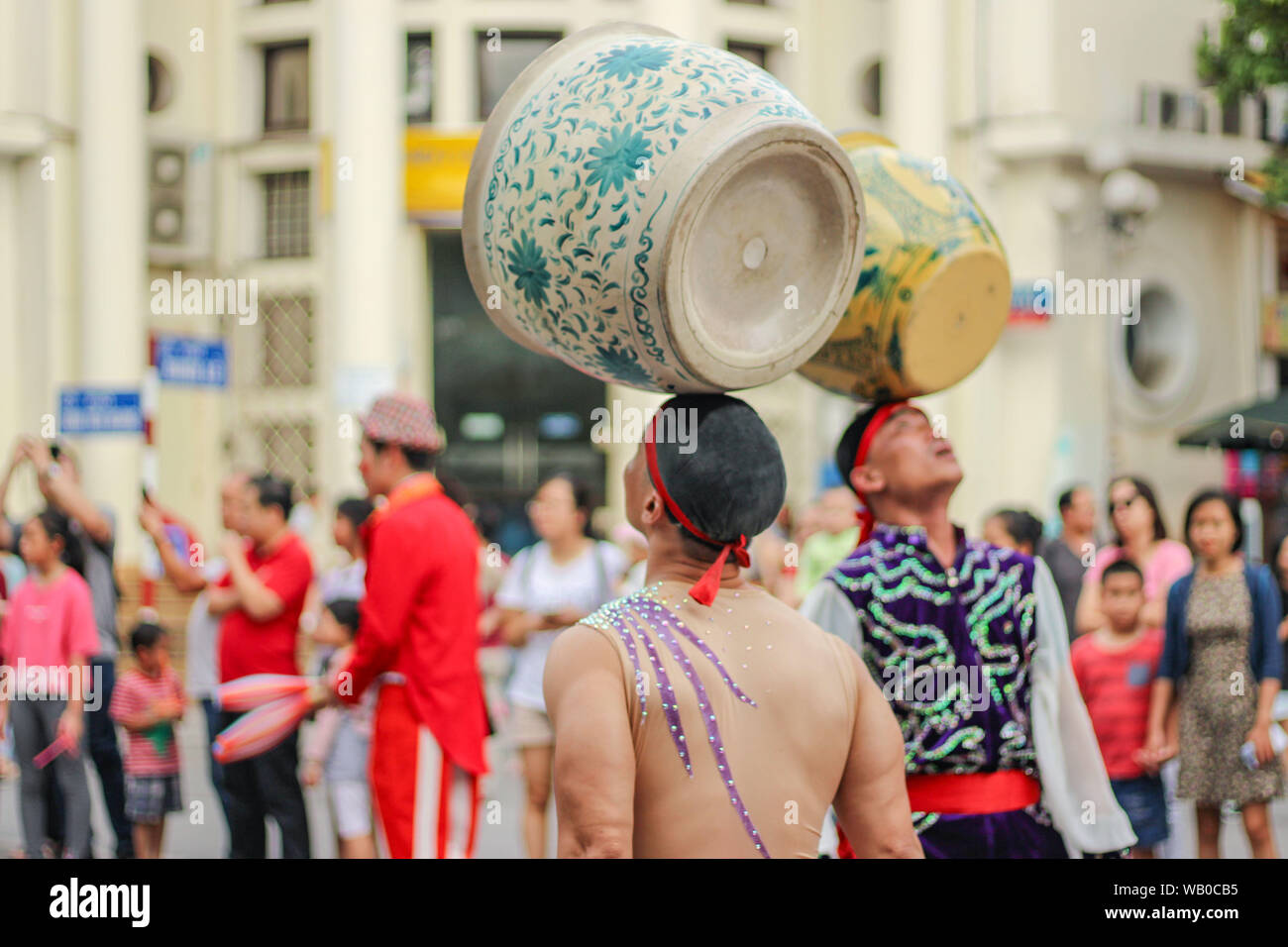 Men carry big ceramic pots on their head in the festival in Hanoi ...