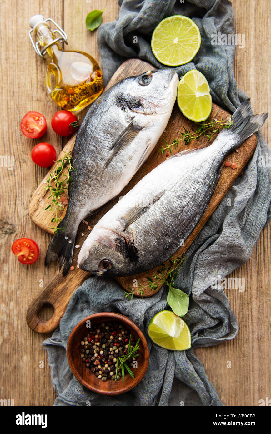 Fresh fish dorado. Dorado and ingredients for cooking on a table Stock ...