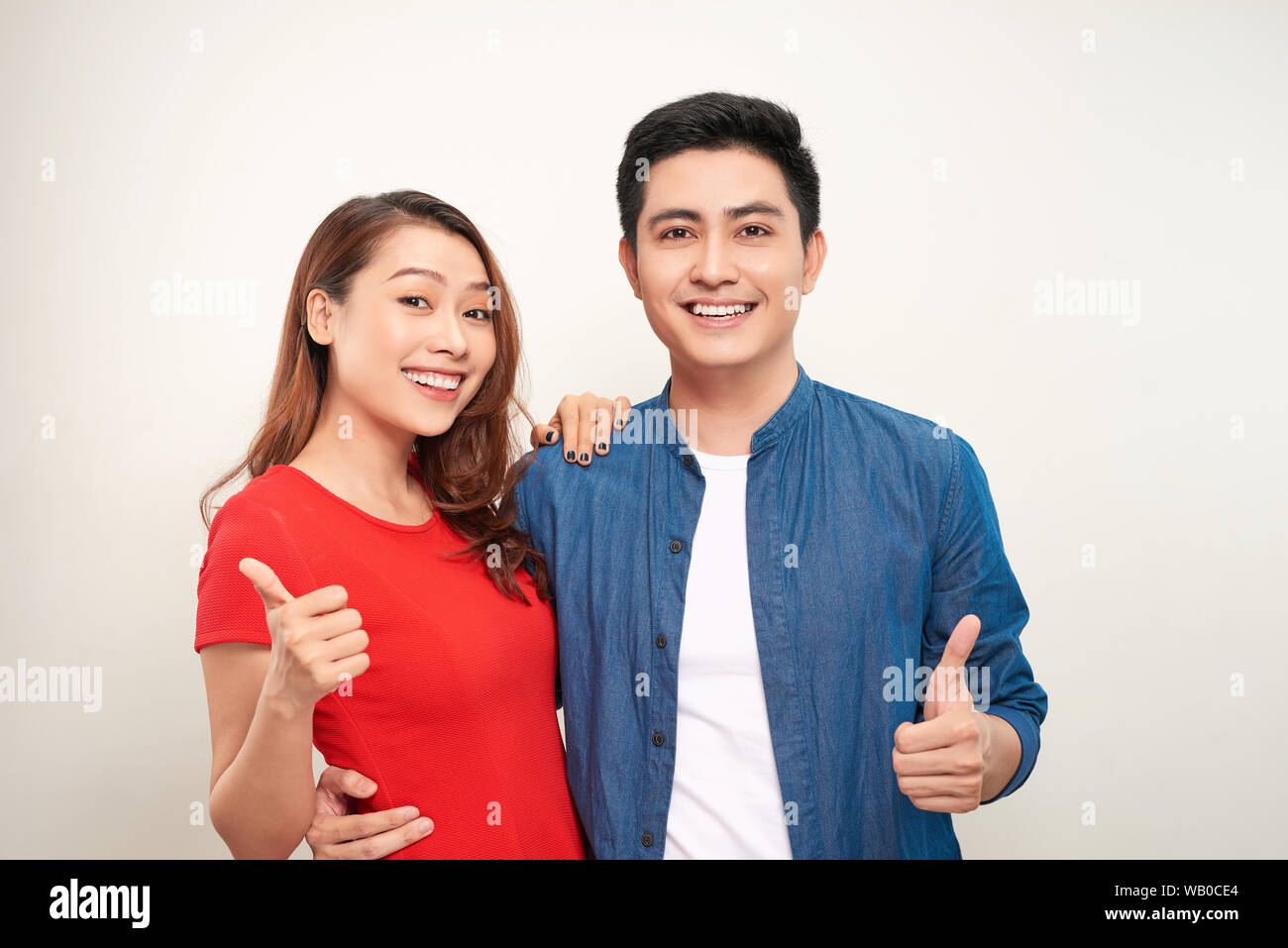 Young couple over isolated background smiling with happy face looking ...
