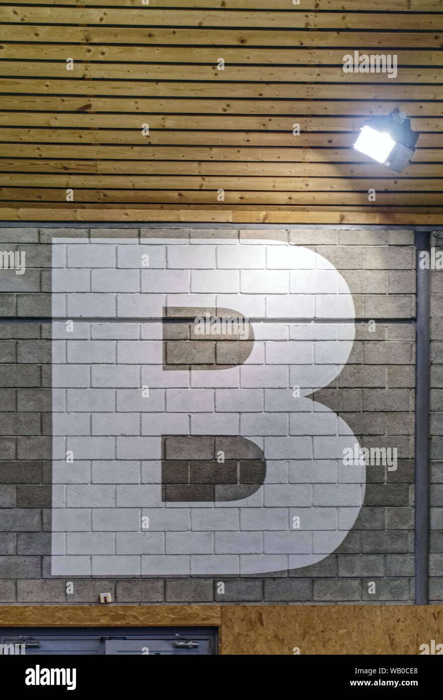 Big letter painted on brick hall wall for devide room for smaller ...