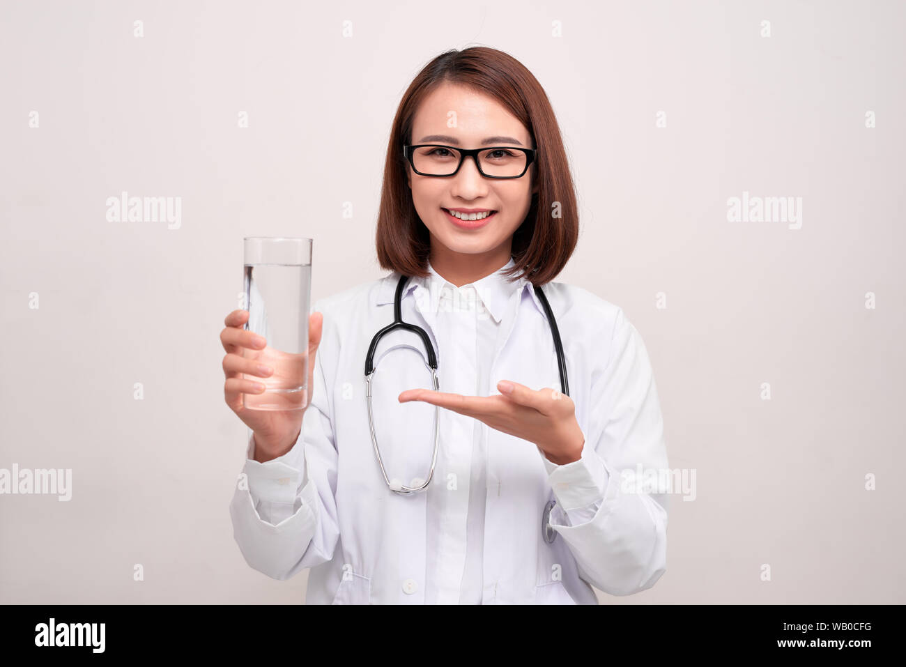 Doctor woman holding water and medicine on white background Stock Photo ...