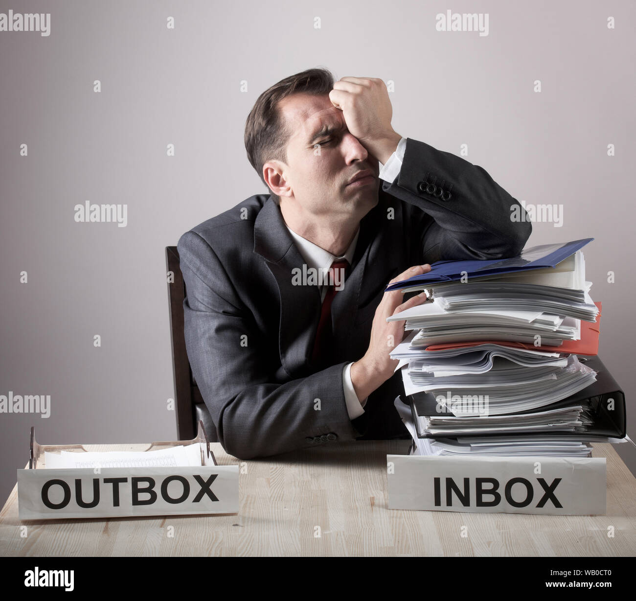Stressed office worker with a paper stack Stock Photo - Alamy